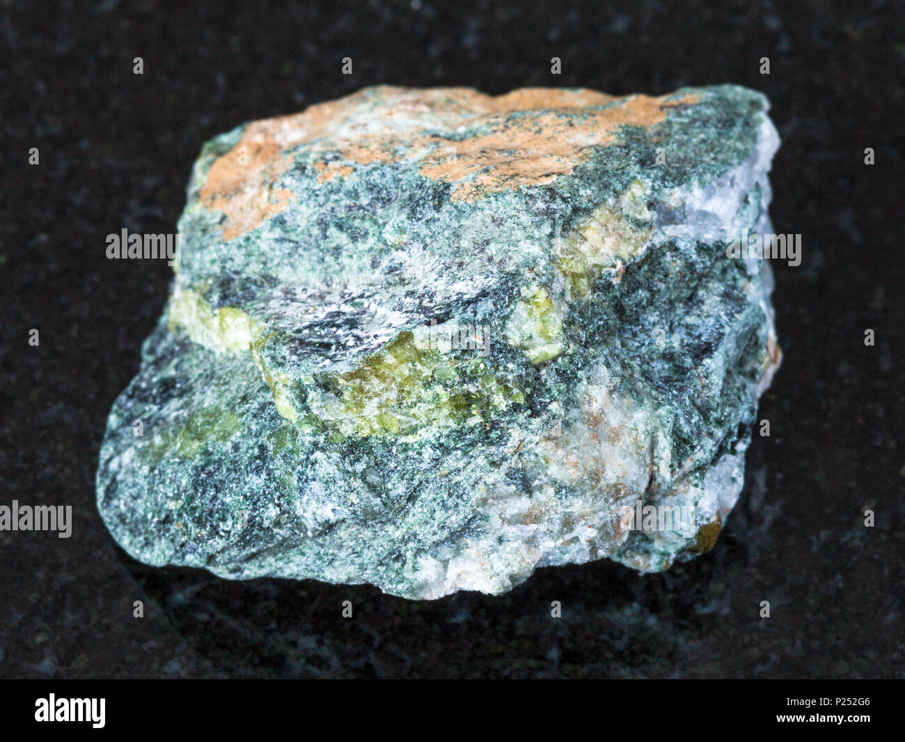 macro shooting of natural mineral - rough beryl rock on black granite ...