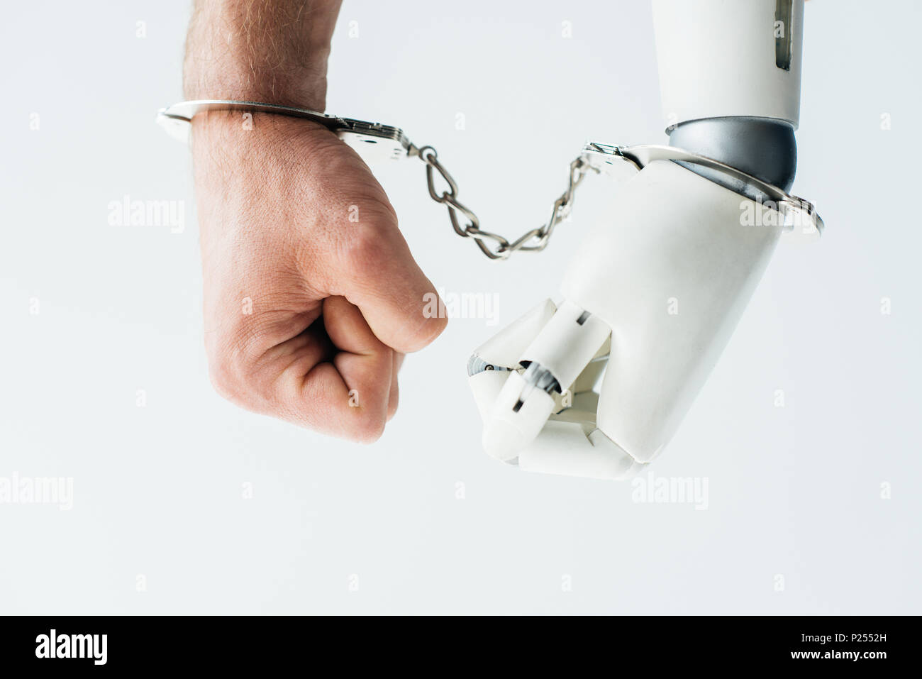 close-up view of human hand and hand of robot in handcuffs isolated on ...