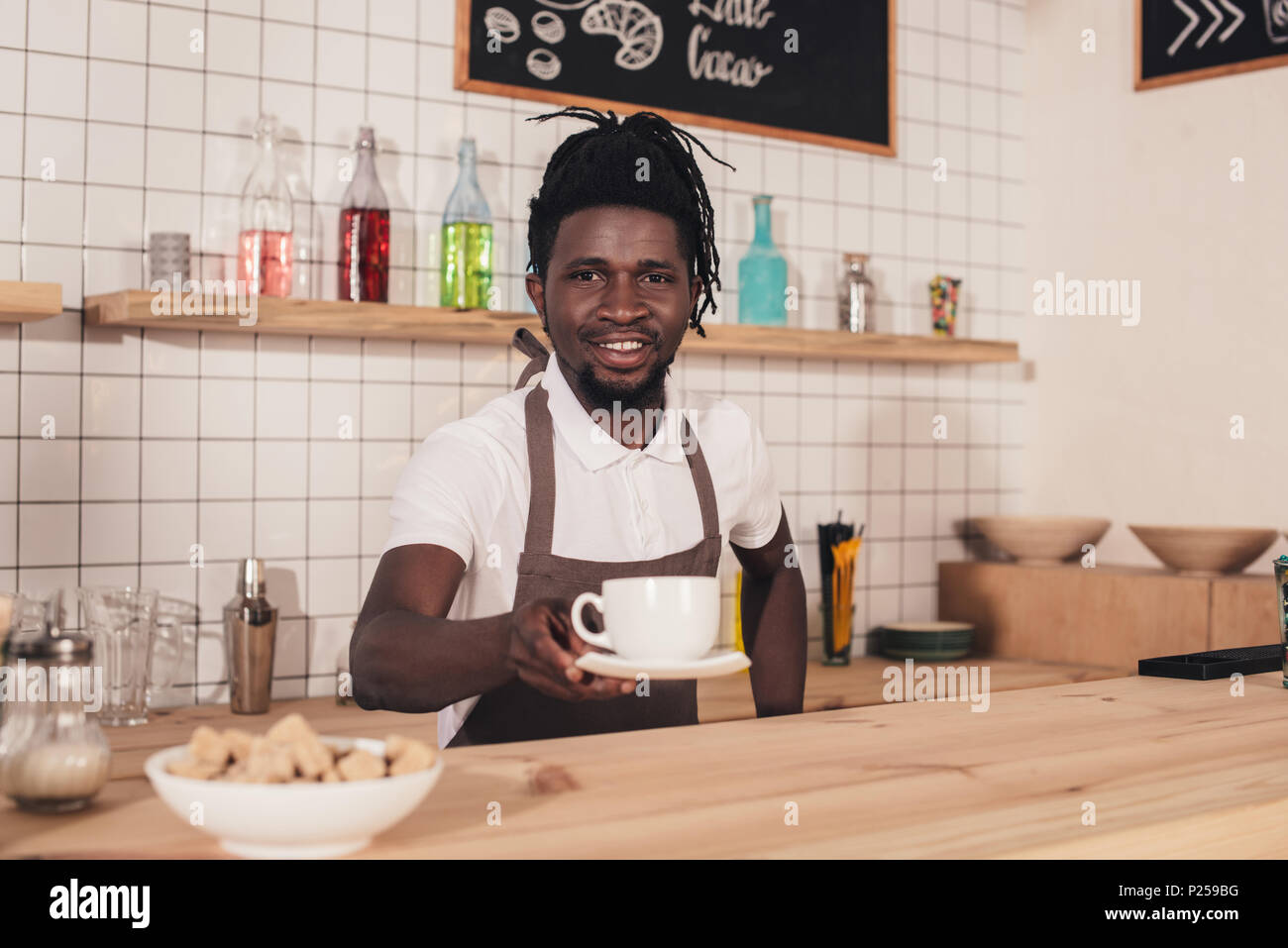 African waiter pouring coffee hi-res stock photography and images - Alamy