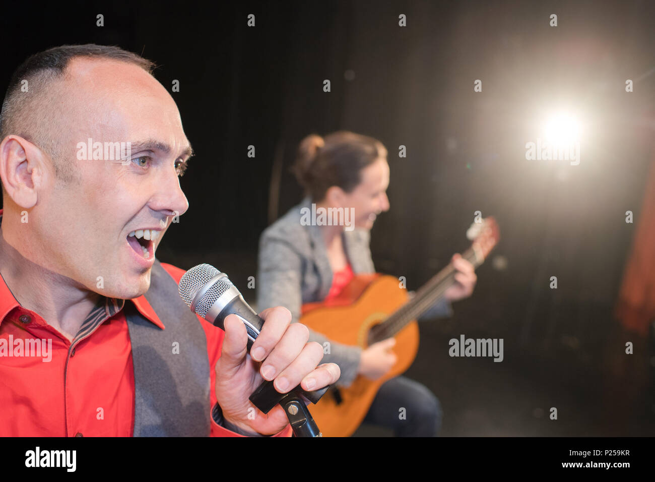 music duo singing and playing guitar at a venue Stock Photo - Alamy