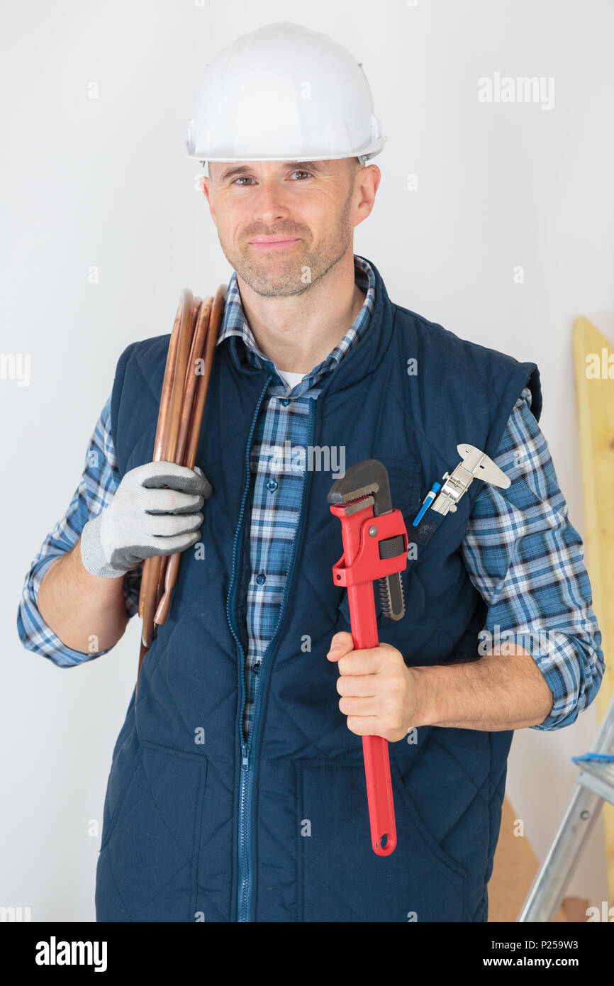 confident plumber holding pipes and tools Stock Photo - Alamy