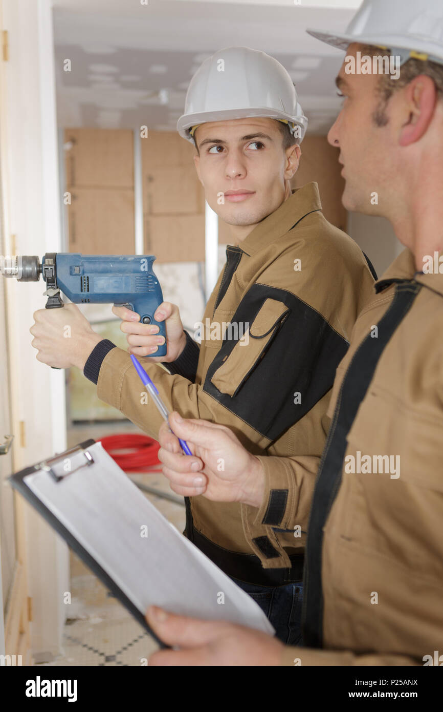 Young worker using electric drill Stock Photo - Alamy
