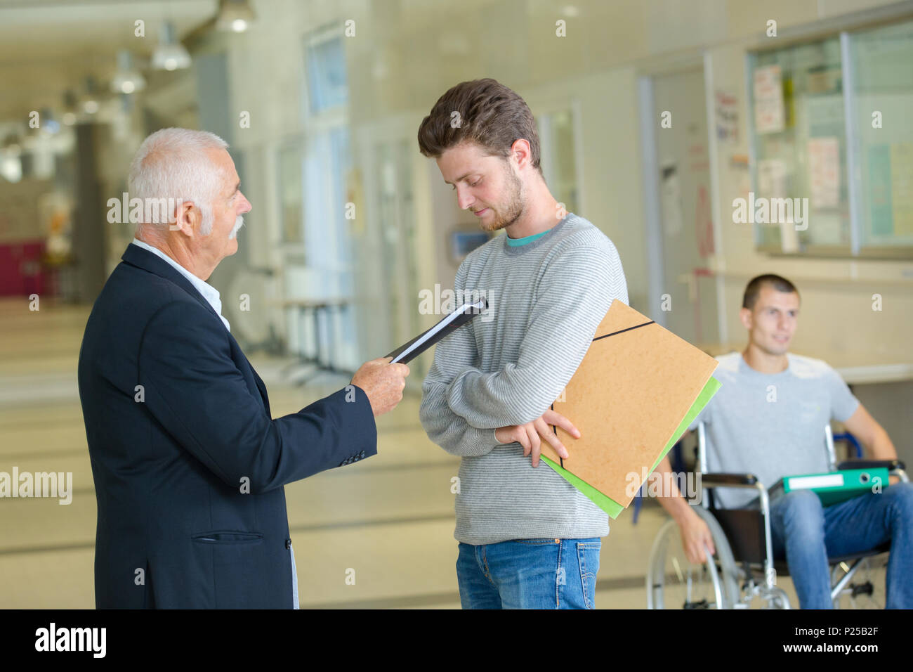 teacher reprimanding young student in school corridor Stock Photo - Alamy