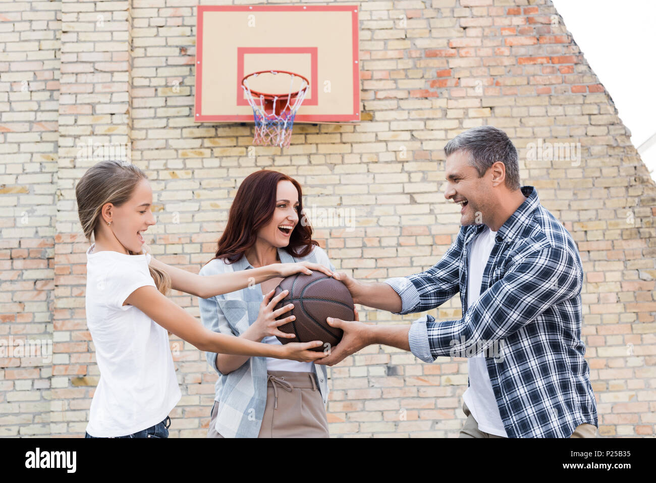 happy family playing basketball together on playground Stock Photo - Alamy