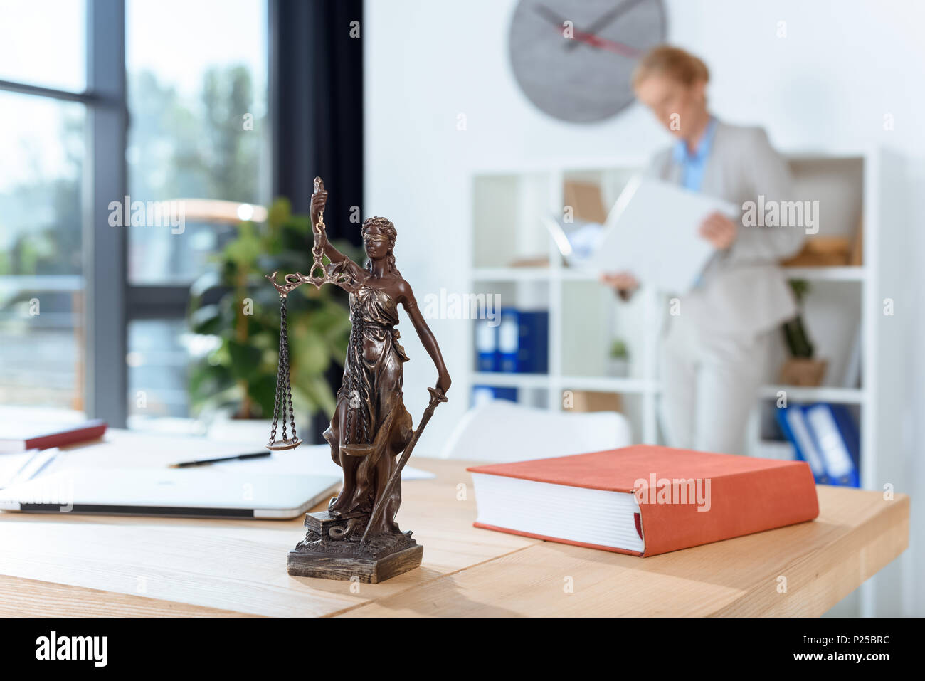 bronze themis sculpture on female lawyer table Stock Photo - Alamy