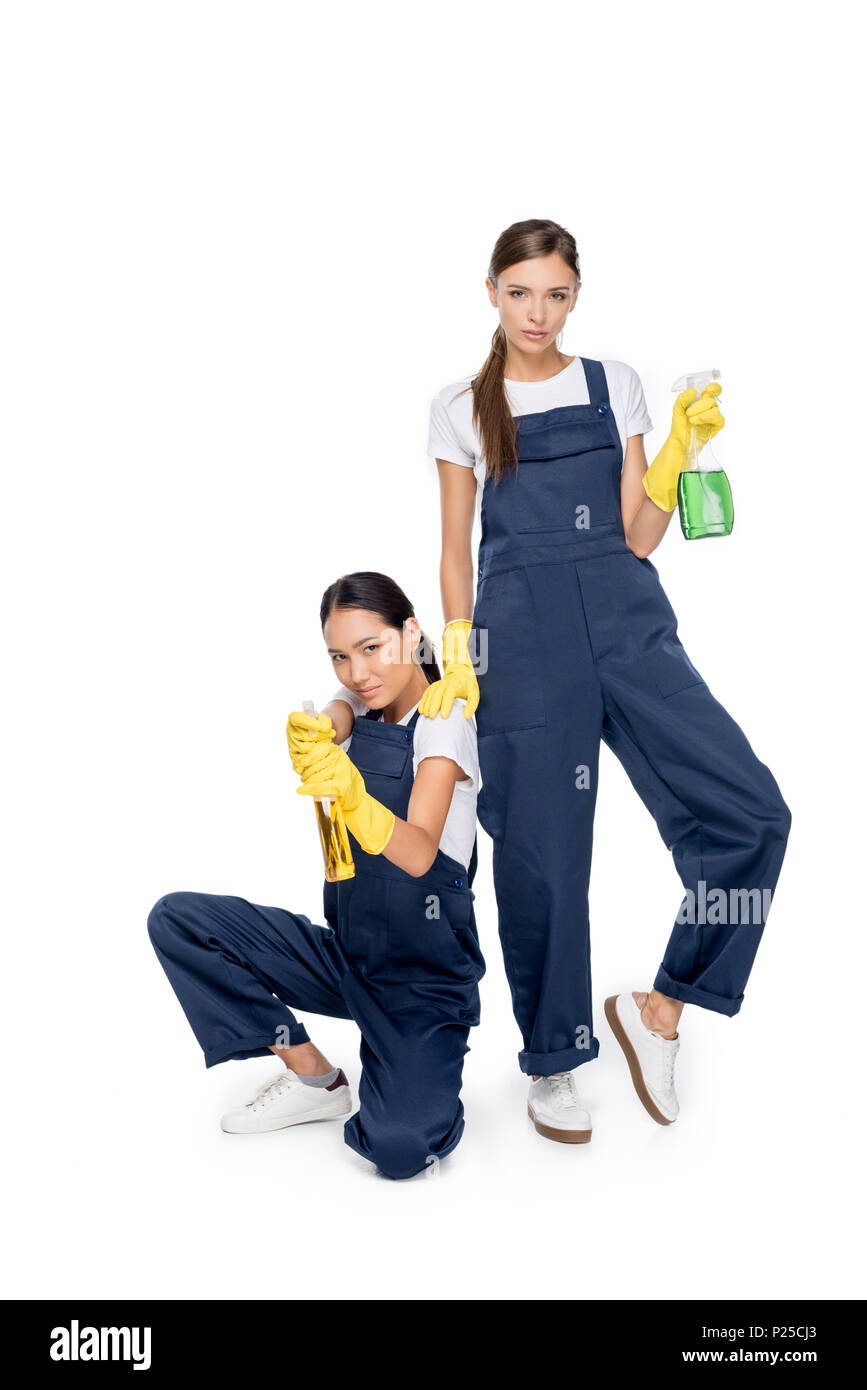 multicultural cleaners in uniform and rubber gloves holding detergents ...