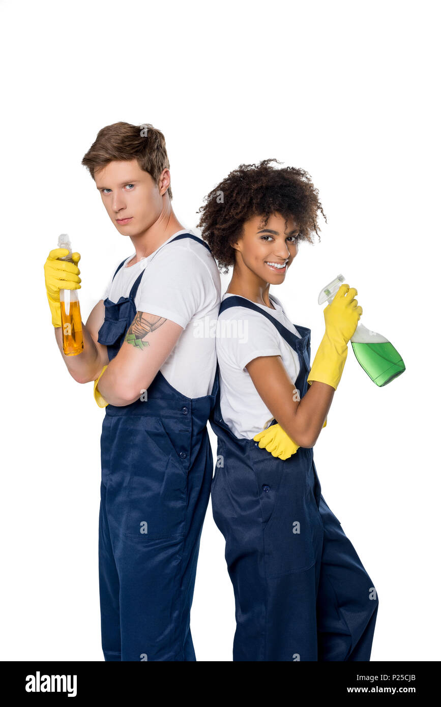 portrait of multiethnic cleaners in rubber gloves with detergents in ...