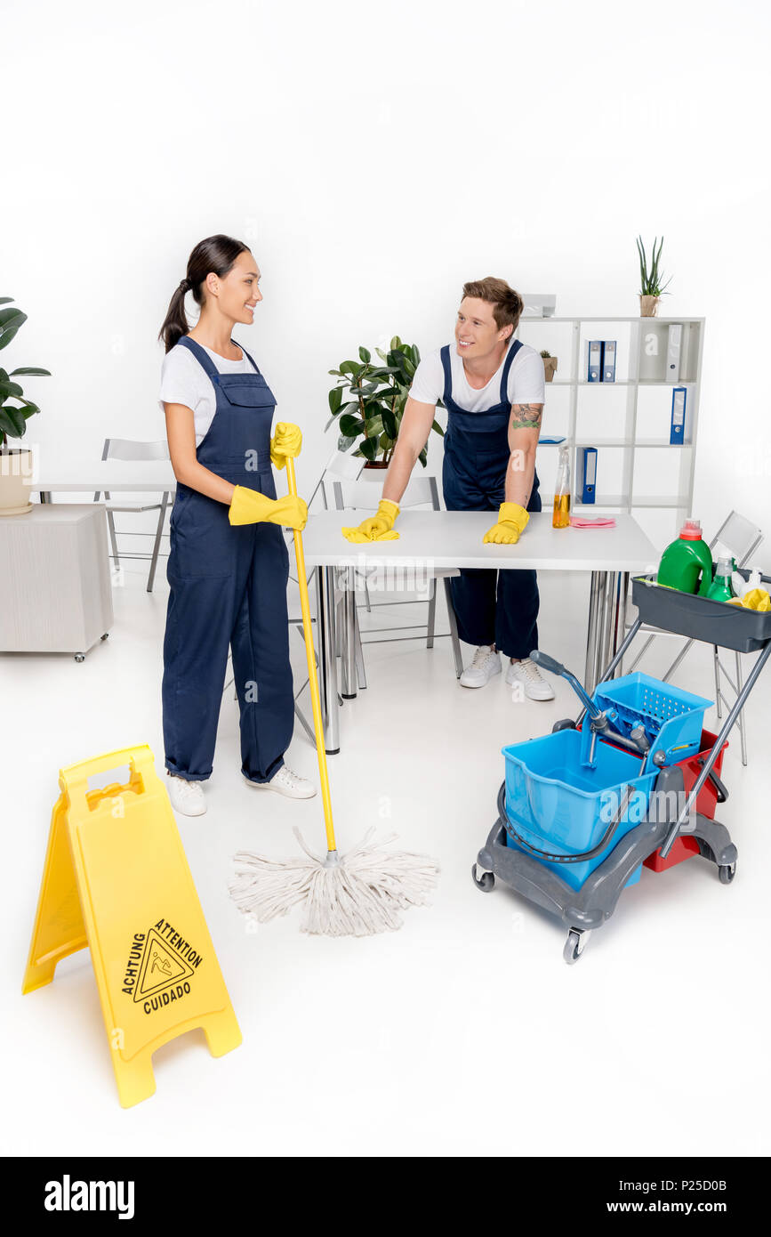 professional young multiethnic cleaners smiling each other while ...