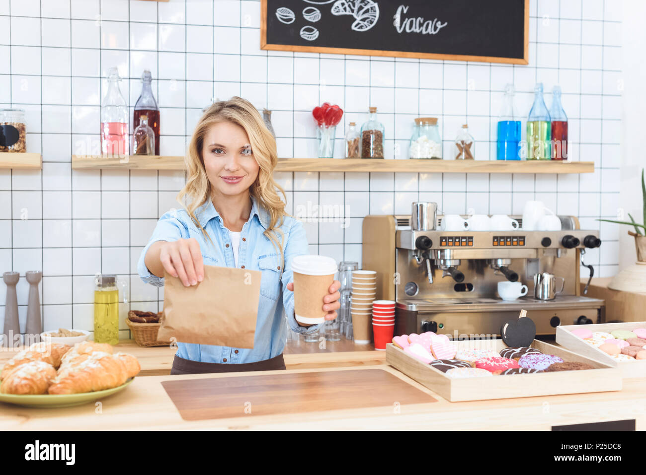 beautiful young waitress holding coffee to go and take away food in ...