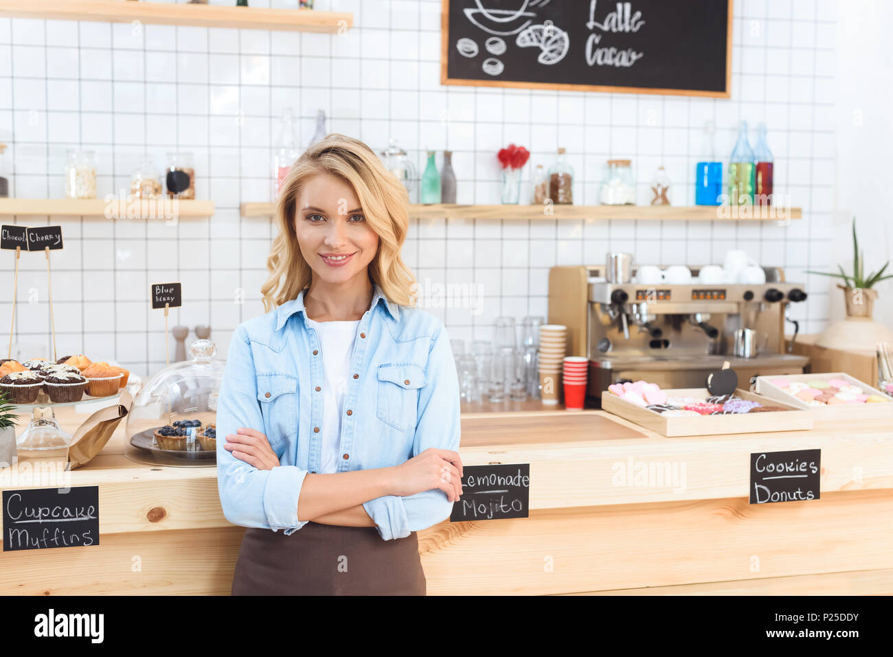 beautiful confident waitress standing with crossed arms and smiling at ...