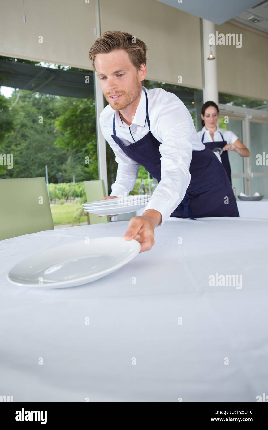 waiter setting a table in a bar Stock Photo - Alamy