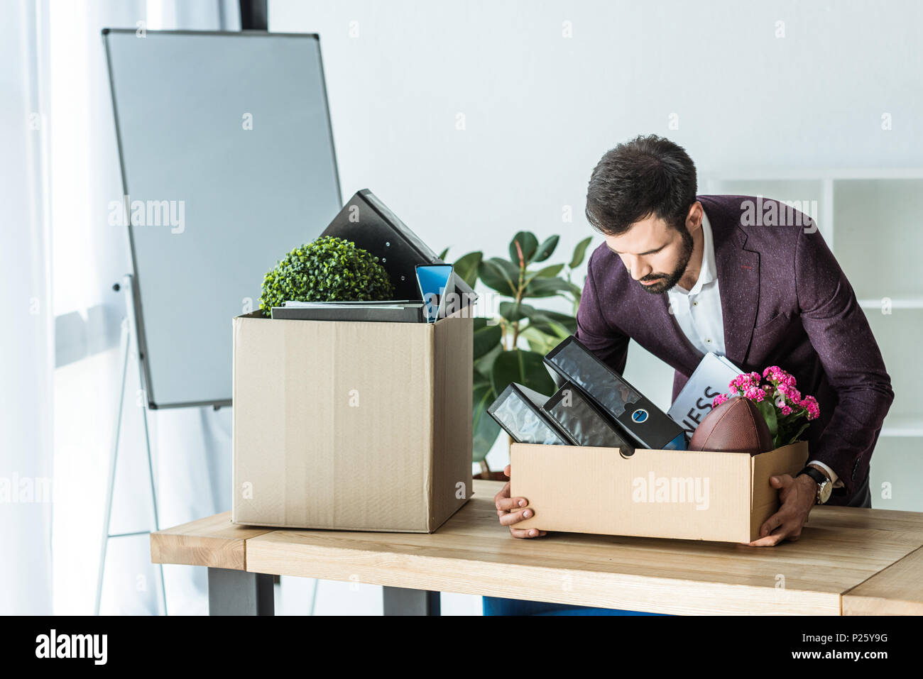 fired businessman taking box of personal stuff from desk at office ...
