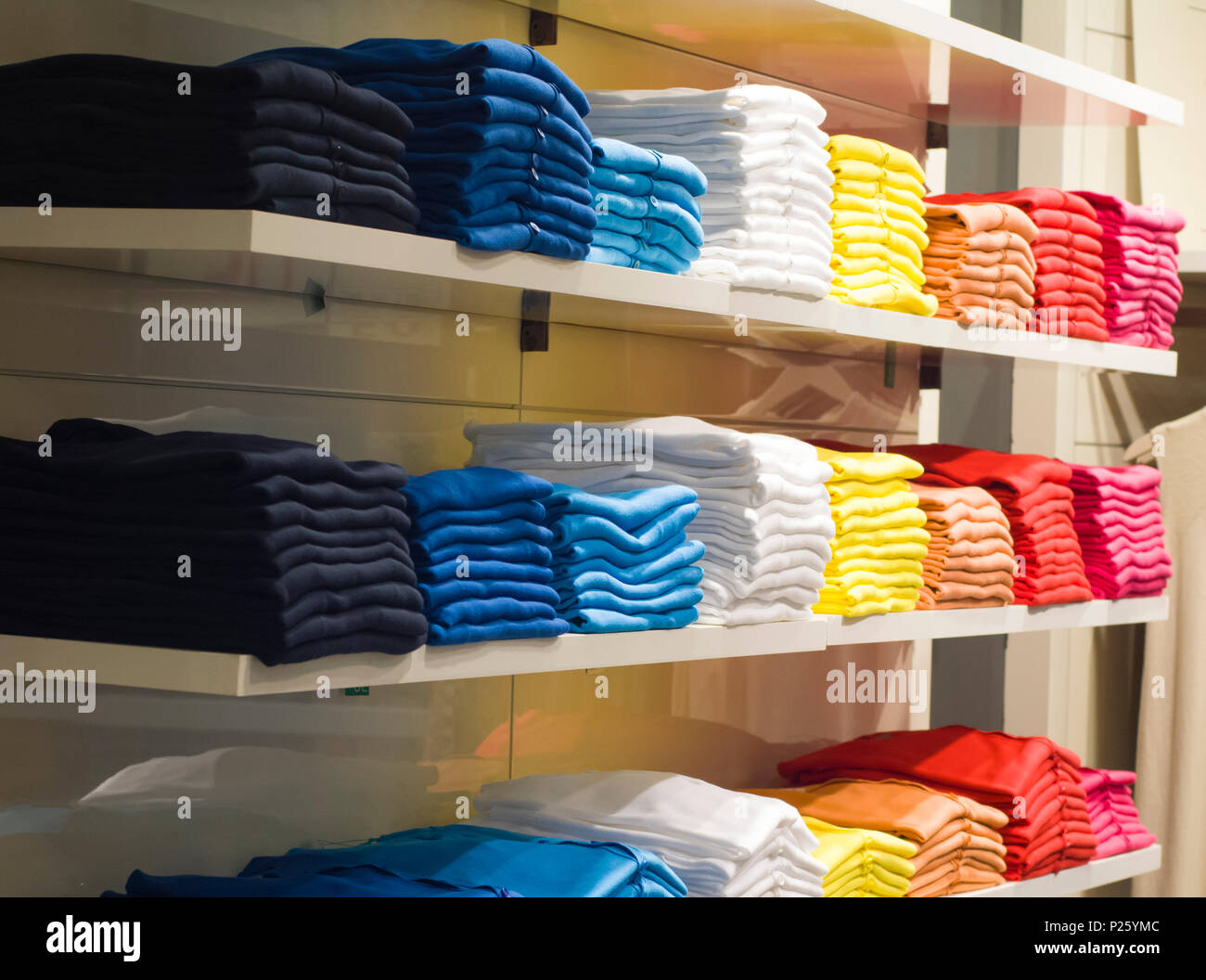 Rows of folded colorful clothes in a shop Stock Photo - Alamy