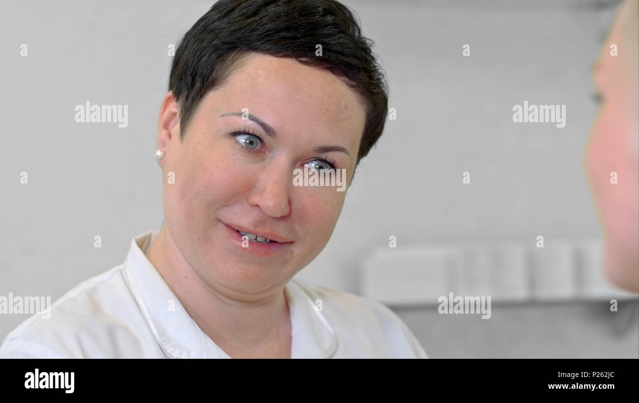 Portrait of a woman with fresh and clean skin talking to her client ...