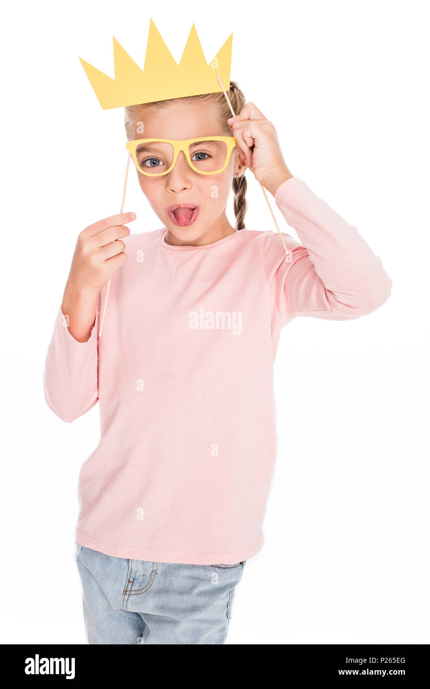 Mischievous child playing with cardboard masks and sticking tongue out ...