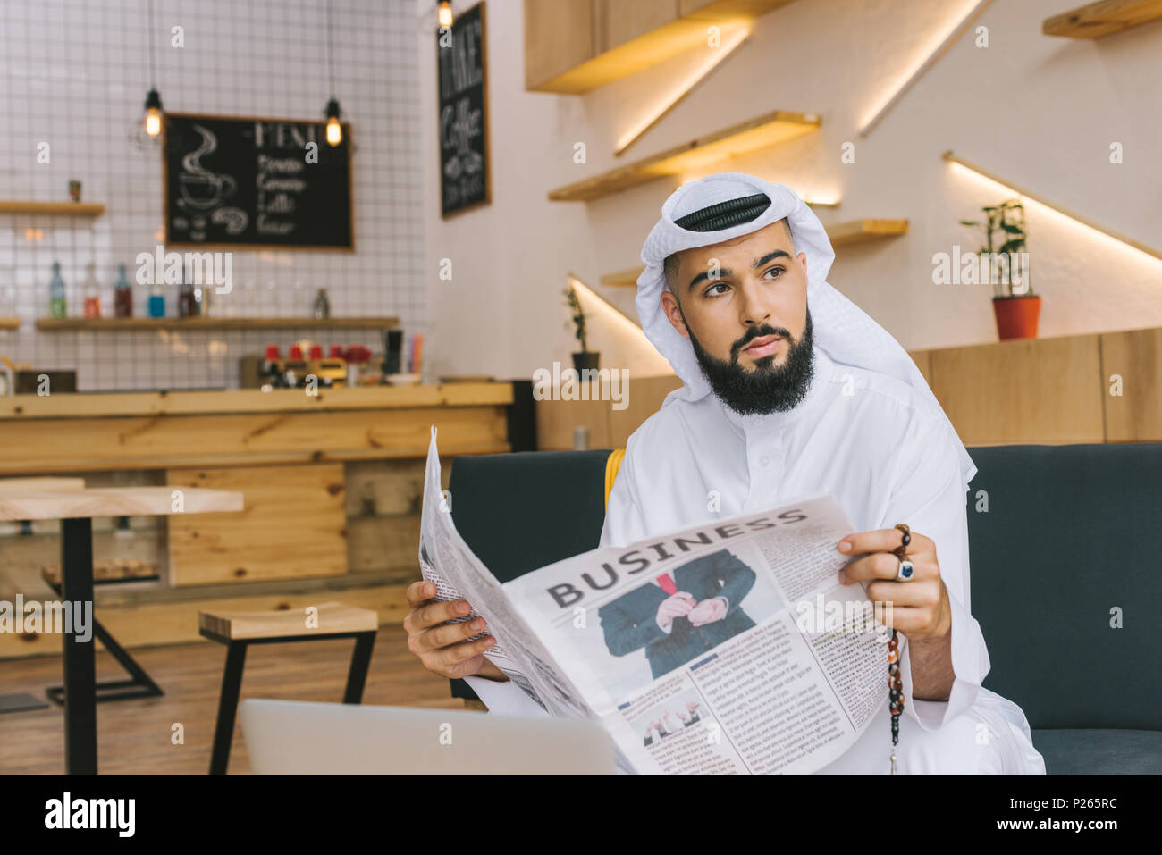 handsome young muslim businessman with newspaper in cafe Stock Photo ...