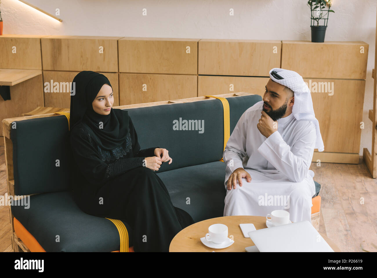 young muslim couple talking while sitting on cozy couch Stock Photo - Alamy