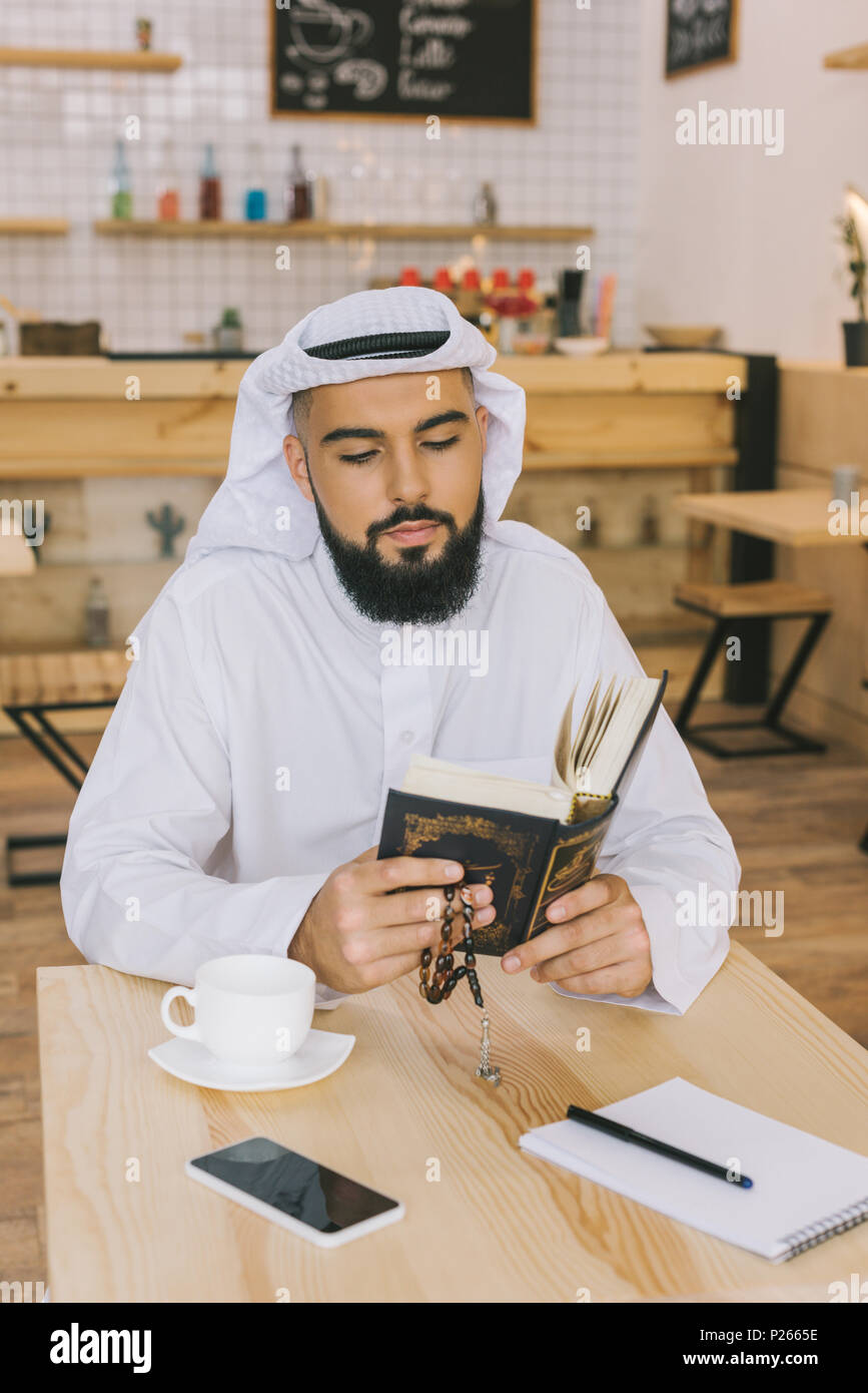 young muslim man reading quran sitting in modern cafe Stock Photo - Alamy