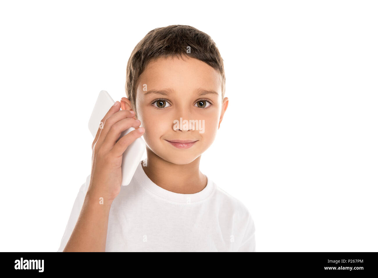 portrait of smiling little boy looking at camera while talking on ...