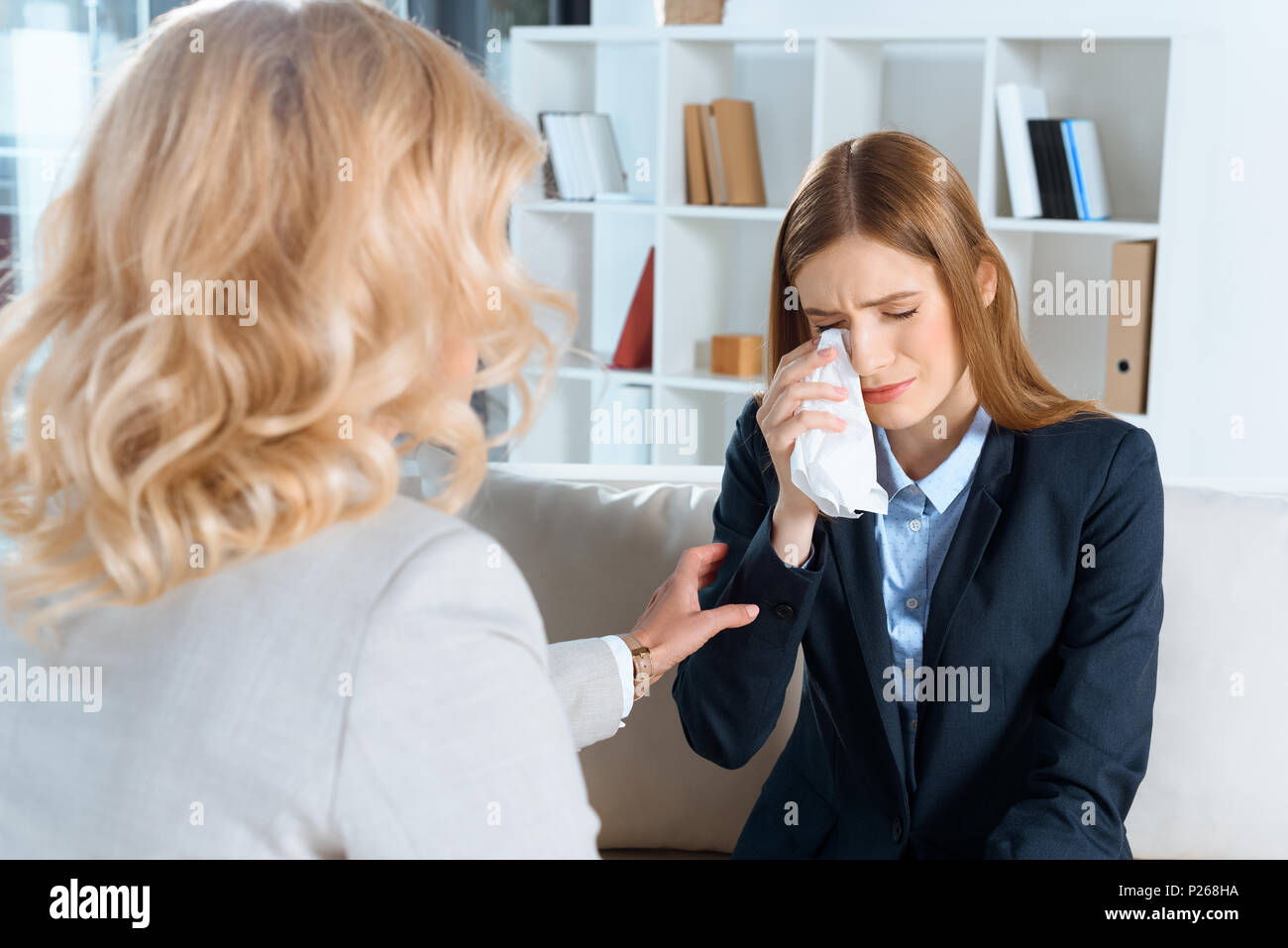 psychologist supporting crying young woman during therapy Stock Photo ...