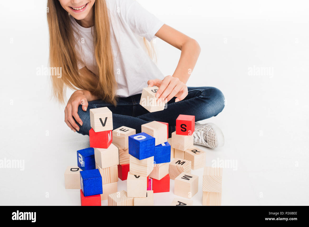 cropped view of female child playing with alphabet blocks, isolated on ...