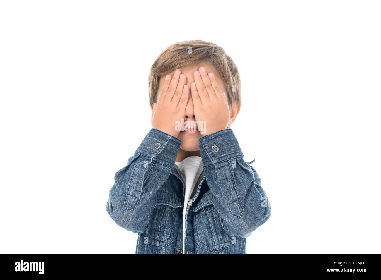 obscured view of little boy covering eyes with hands isolated on white ...