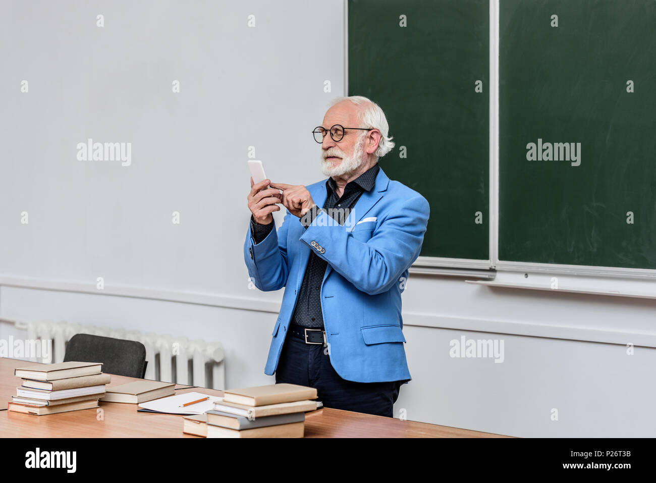 grey hair professor looking at smartphone in lecture room Stock Photo ...