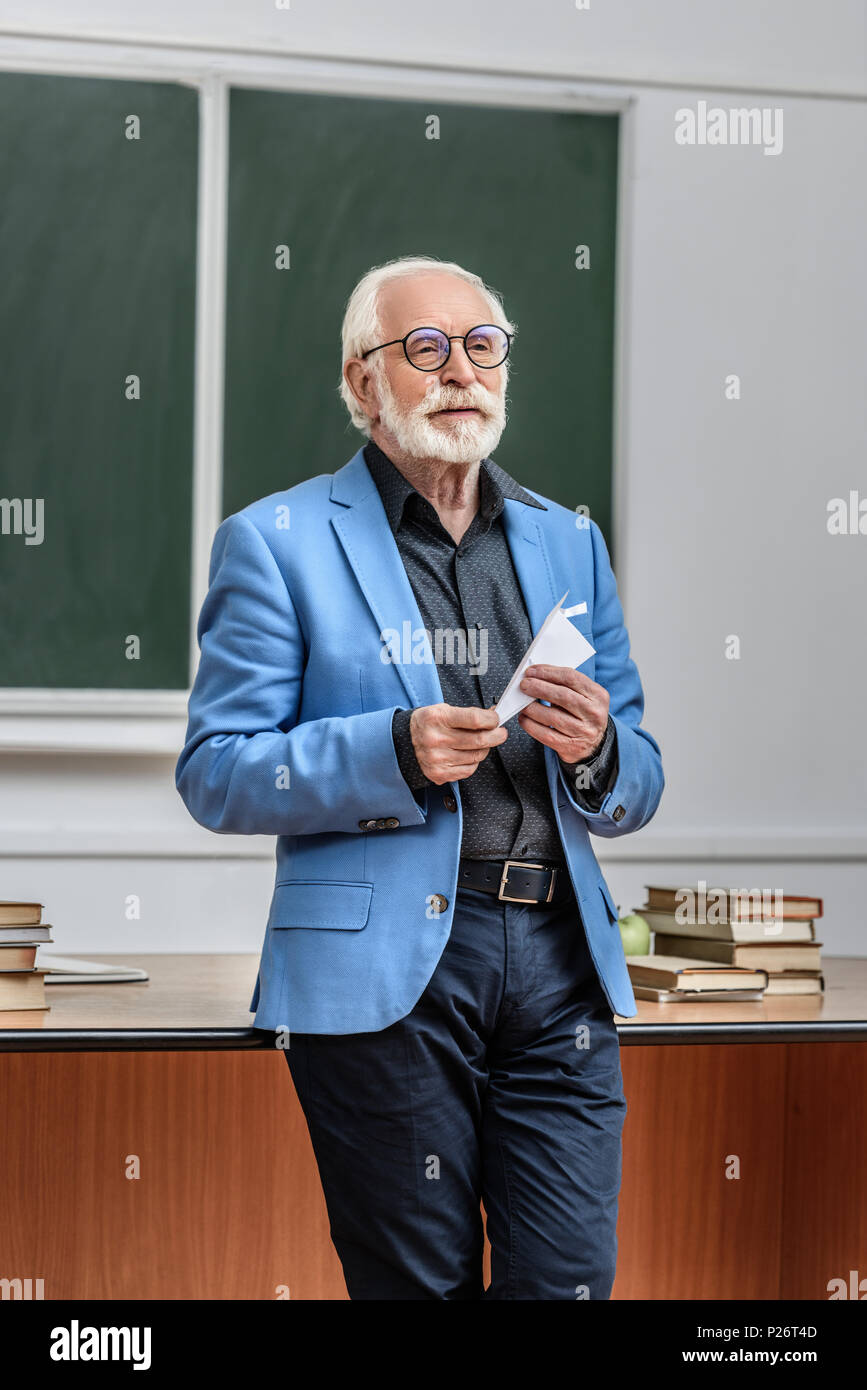 grey hair professor holding paper plane in lecture hall Stock Photo - Alamy