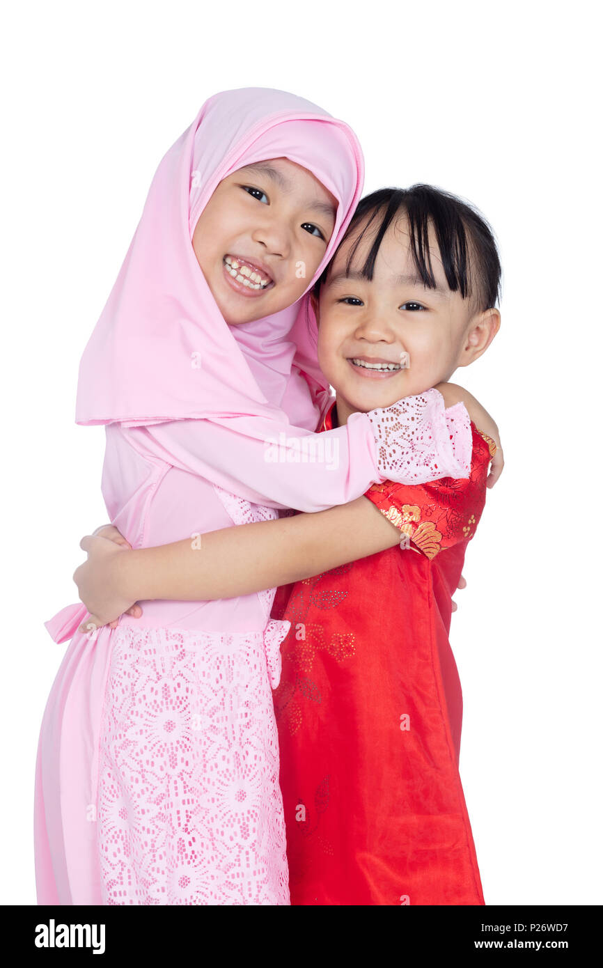 Asian Chinese little sisters wearing cheongsam and traditional Malay ...