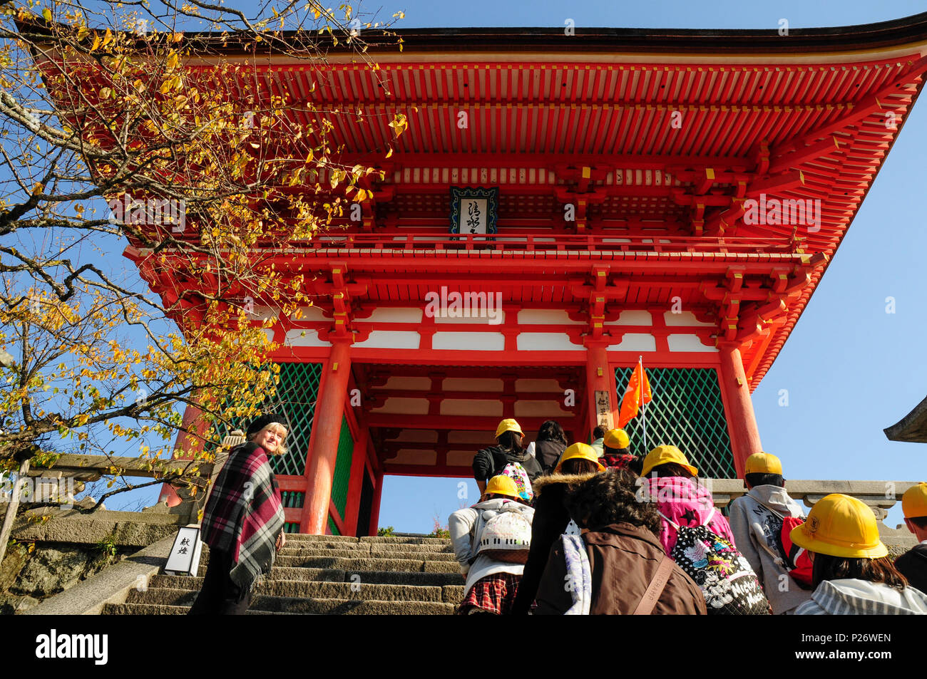 A female foreign tourist is overtaken by a tour party at the entrance ...