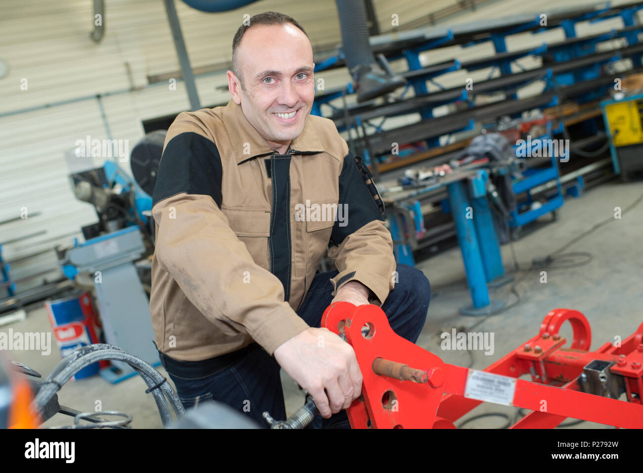 mechanic fixing plow on the tractor Stock Photo - Alamy