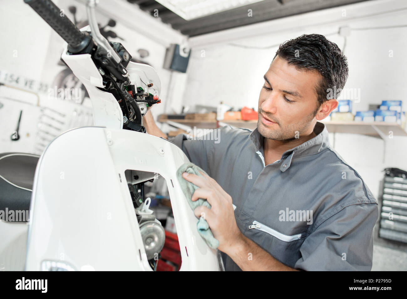 Mechanic cleaning a scooter Stock Photo - Alamy