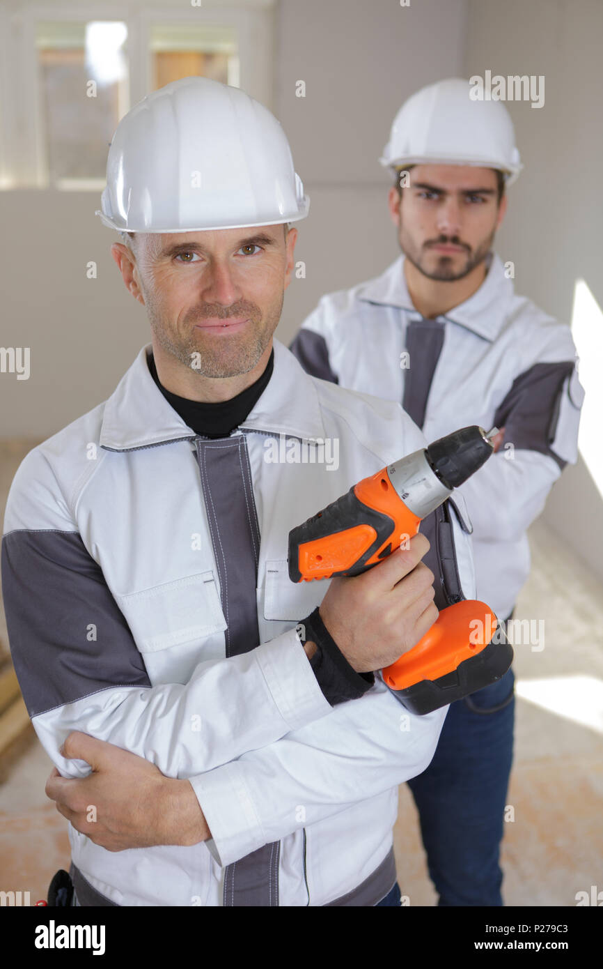Portrait of workmen holding power tool Stock Photo - Alamy