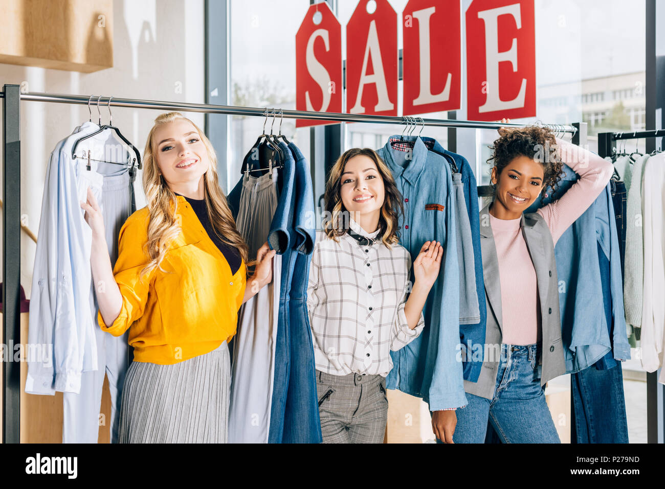 group of multiethnic young women on shopping in clothing store Stock ...