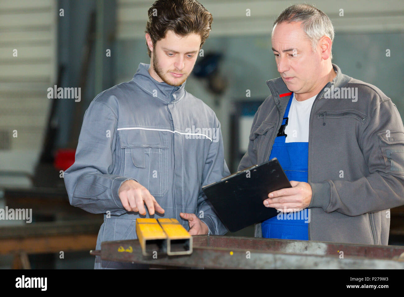 apprentice being shown how to cut sheet metal Stock Photo - Alamy