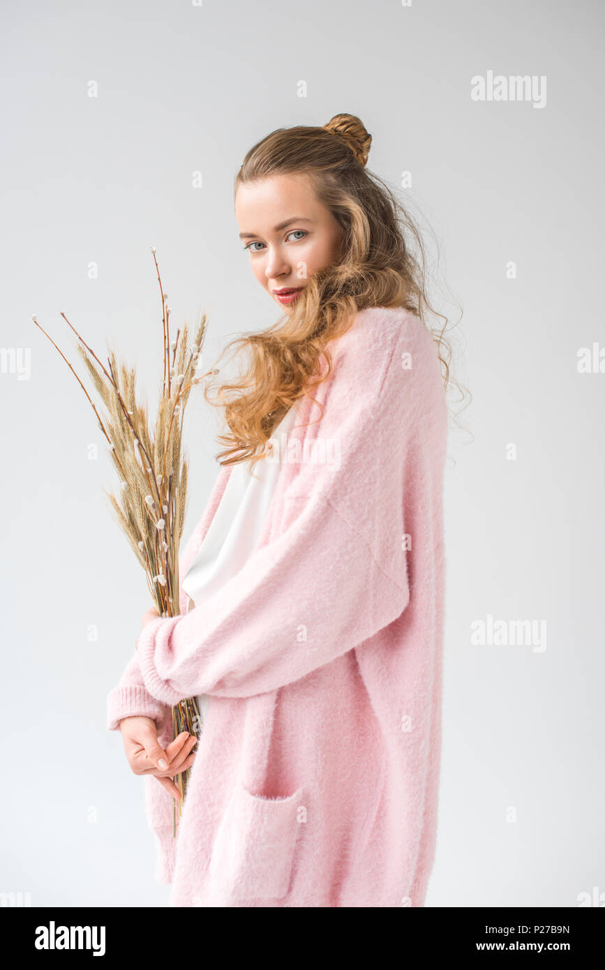 cheerful girl standing and holding bunch of willow tree branches ...
