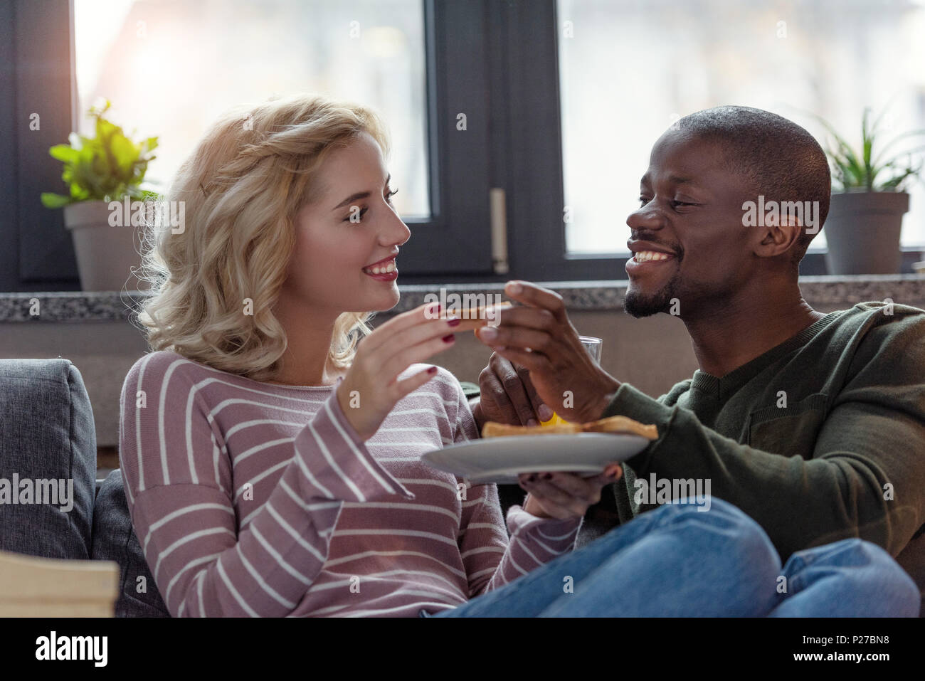 portrait of happy multicultural young couple having breakfast together ...
