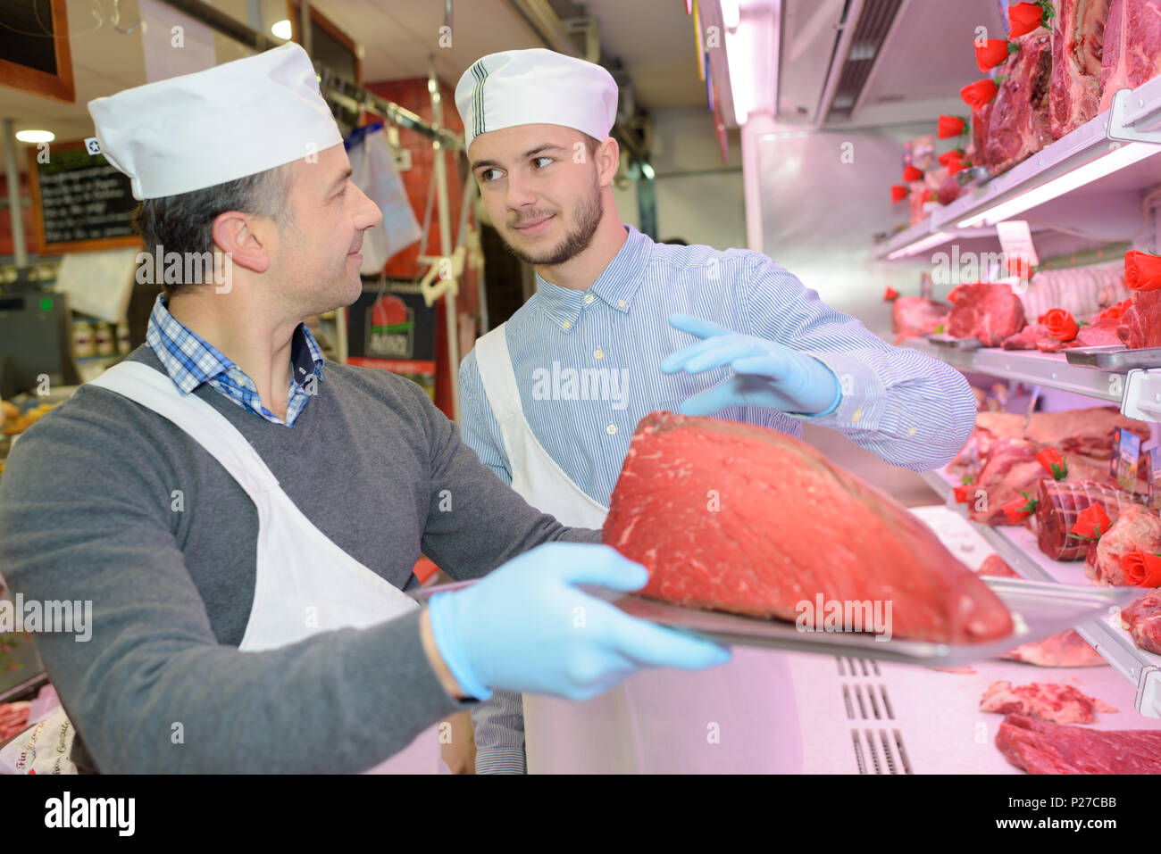 Butcher holding large joint of meat on a tray Stock Photo - Alamy