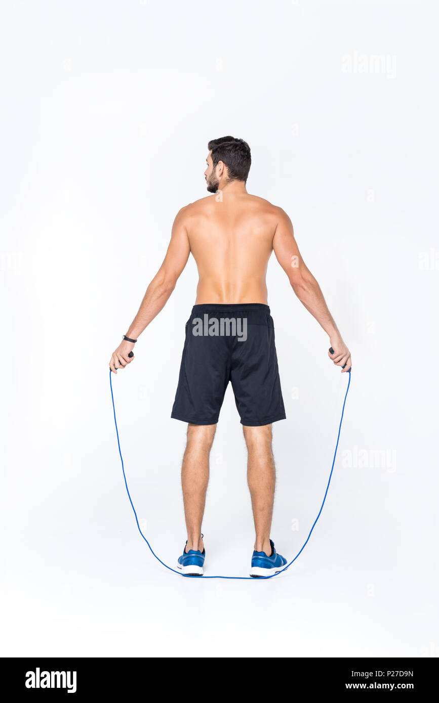 back view of young shirtless sportsman jumping over rope isolated on ...