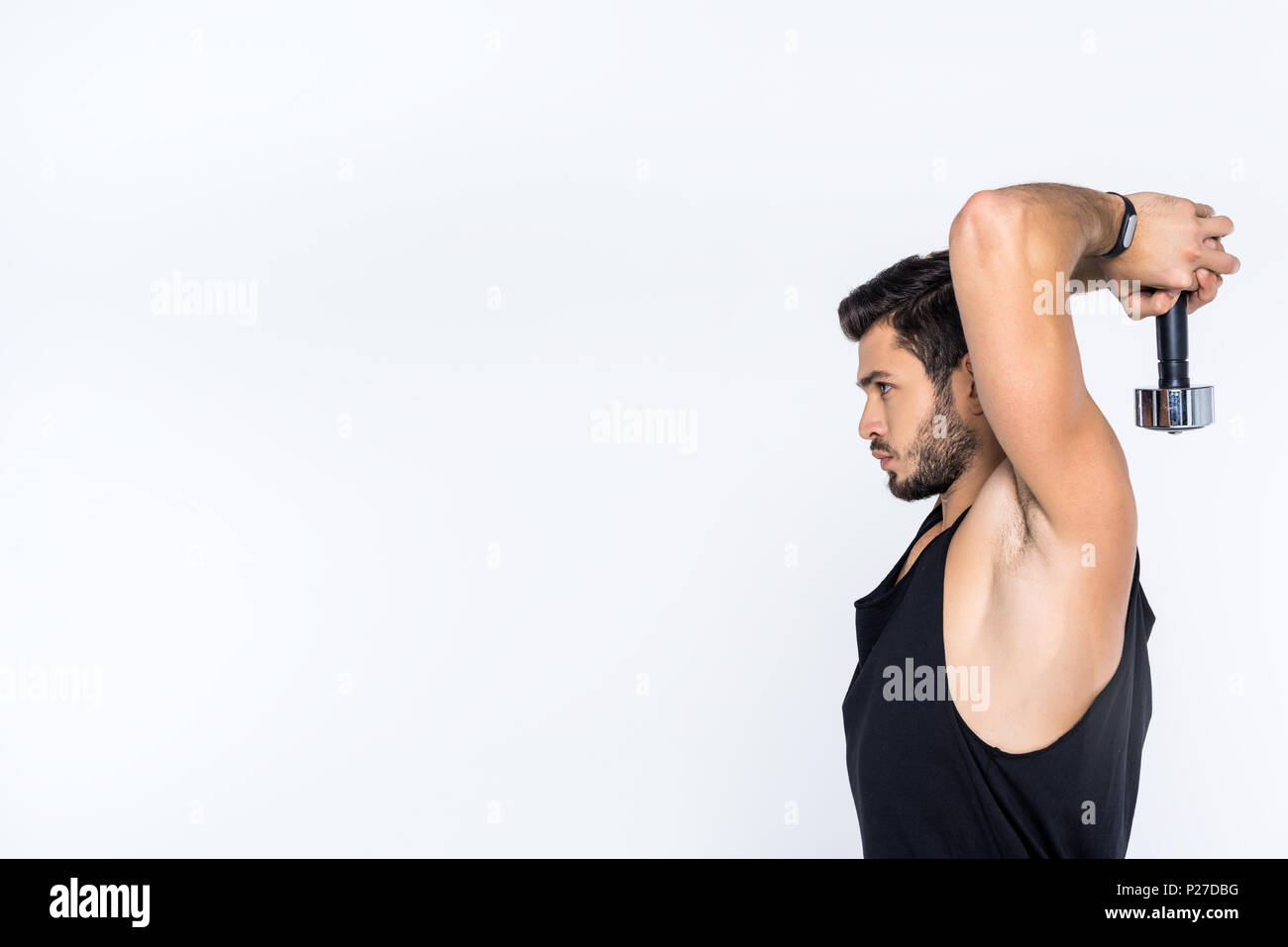 side view of young man working out with dumbbell isolated on white ...