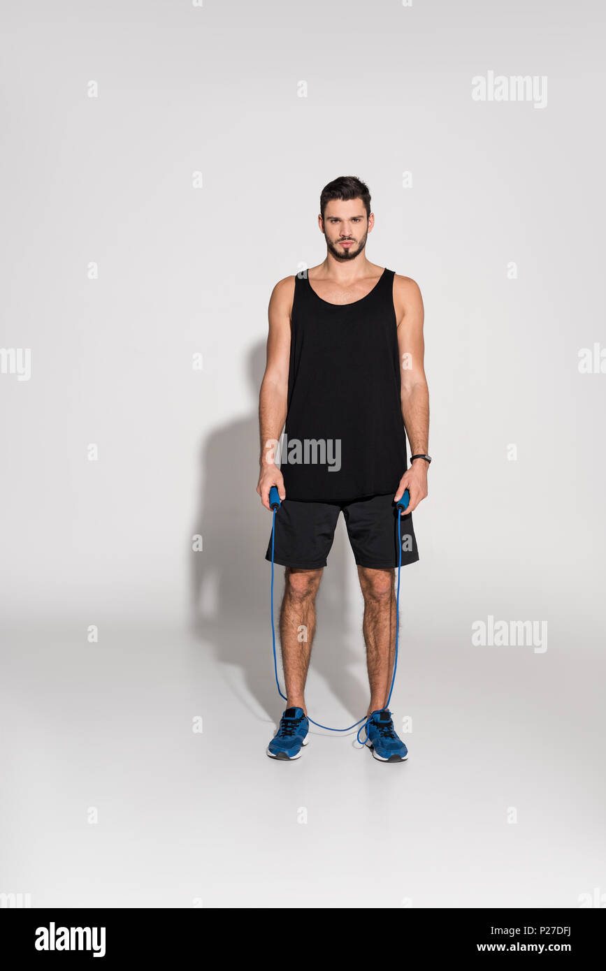 sporty young man with jumping rope on white Stock Photo - Alamy