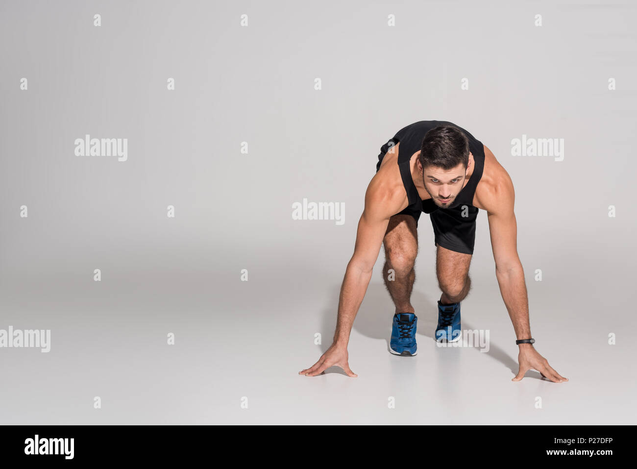 sportive young runner in start position on white Stock Photo - Alamy