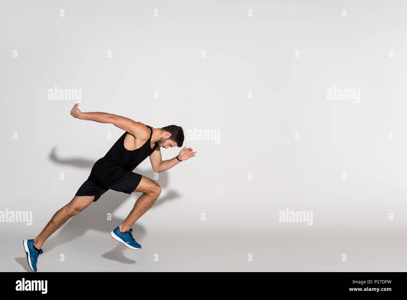 side view of young man running on white Stock Photo - Alamy