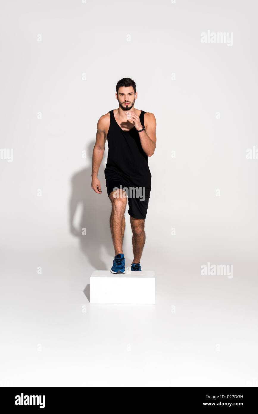 handsome young man doing step aerobics on block Stock Photo - Alamy