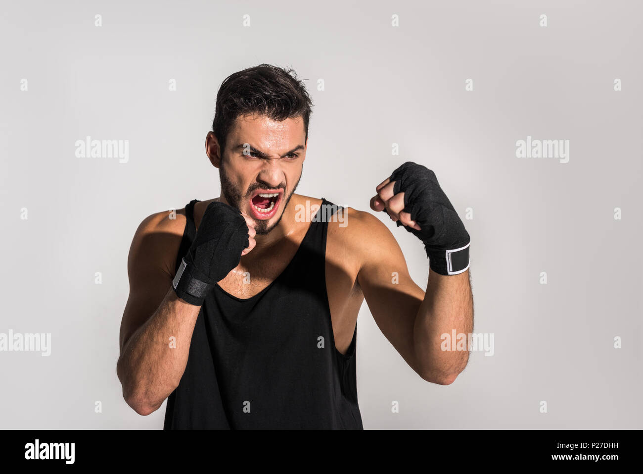 agressive screaming fighter with bandaged hands isolated on grey Stock ...