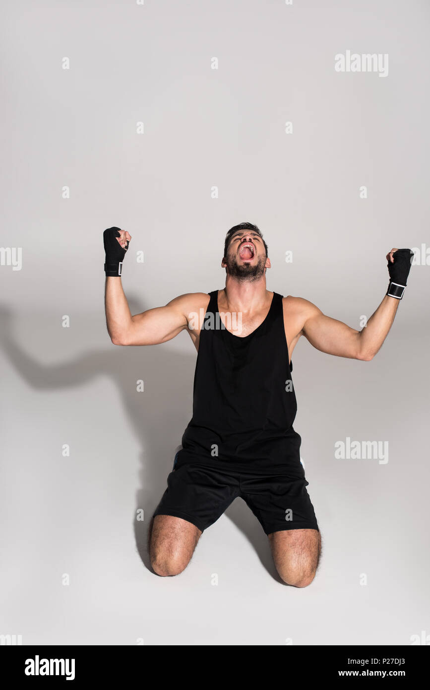 shouting fighter standing on knees on white surface Stock Photo - Alamy