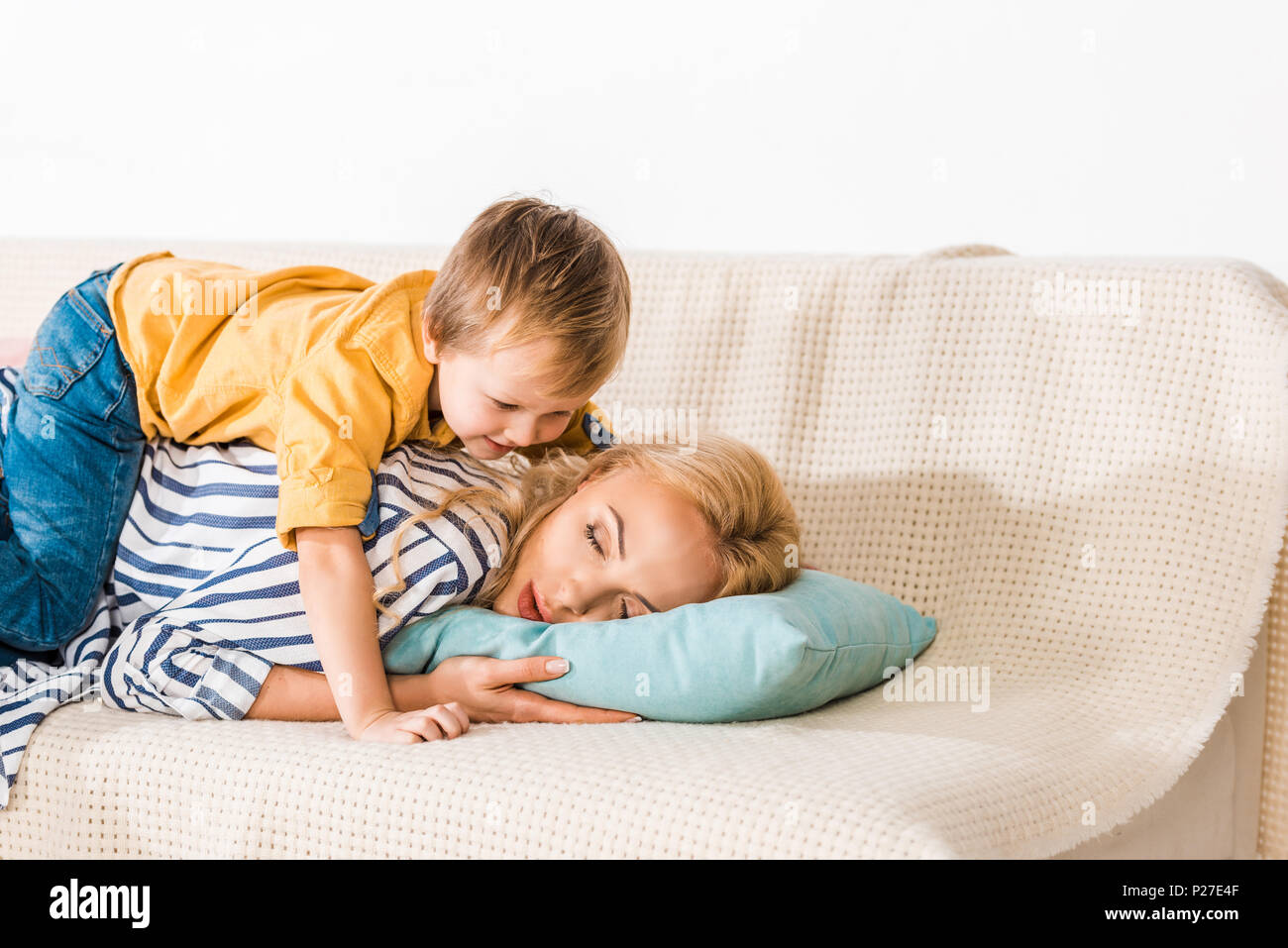 cute little smiling boy hugging mother sleeping on sofa at home Stock ...