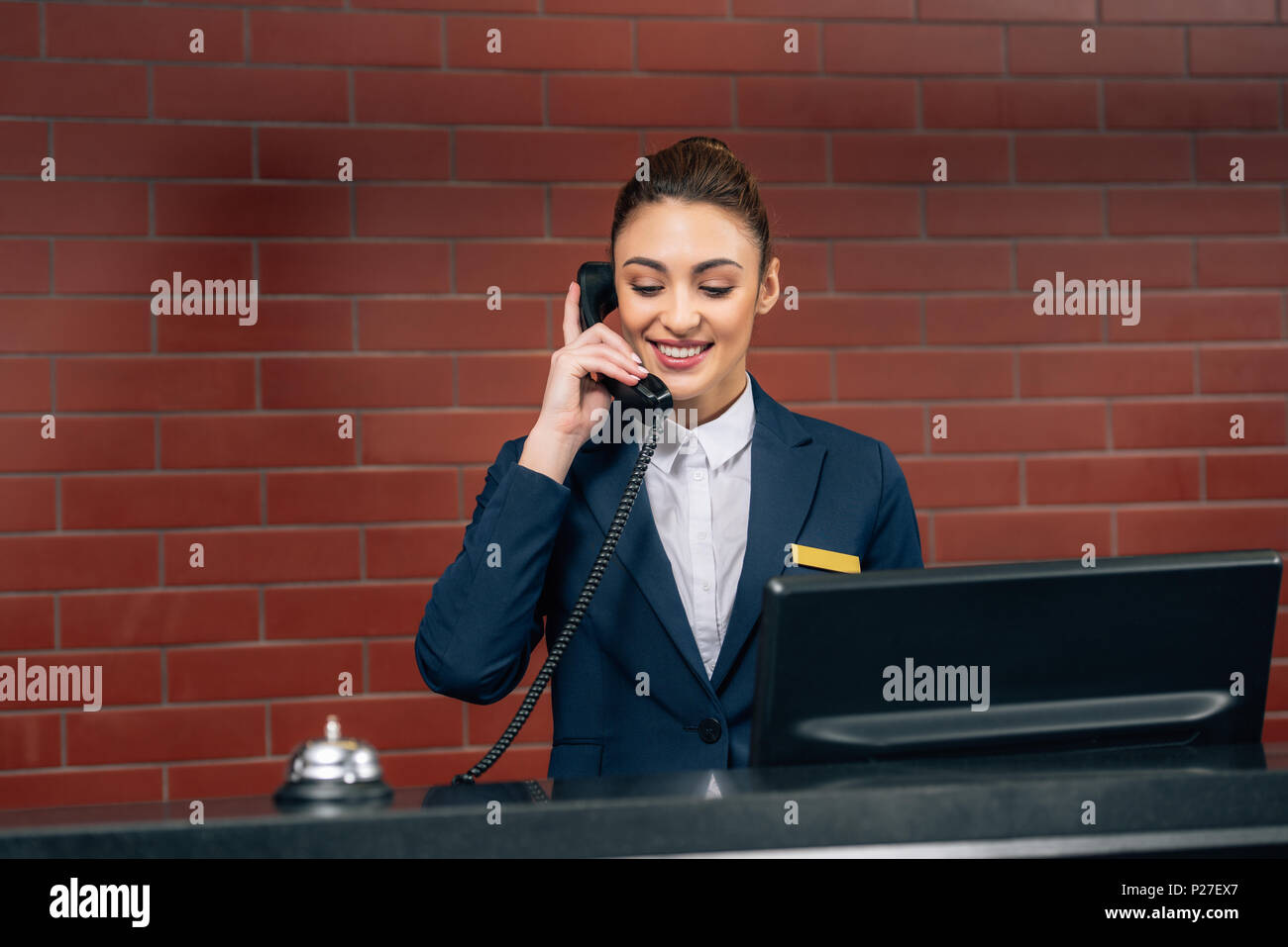 young beautiful hotel receptionist receiving call at workplace Stock ...