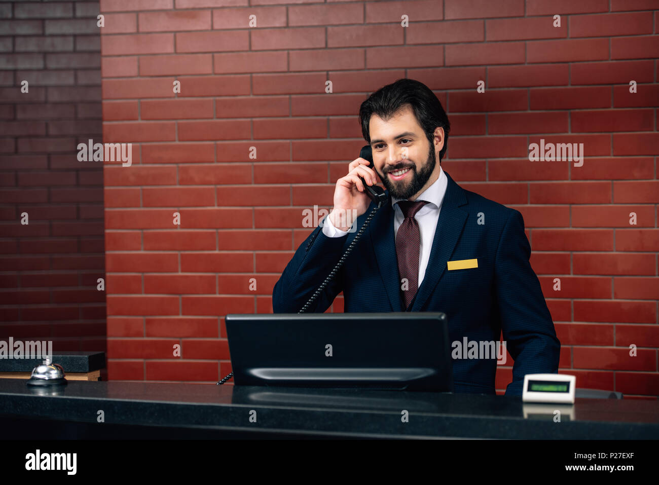 smiling hotel receptionist taking phone call at workplace Stock Photo ...