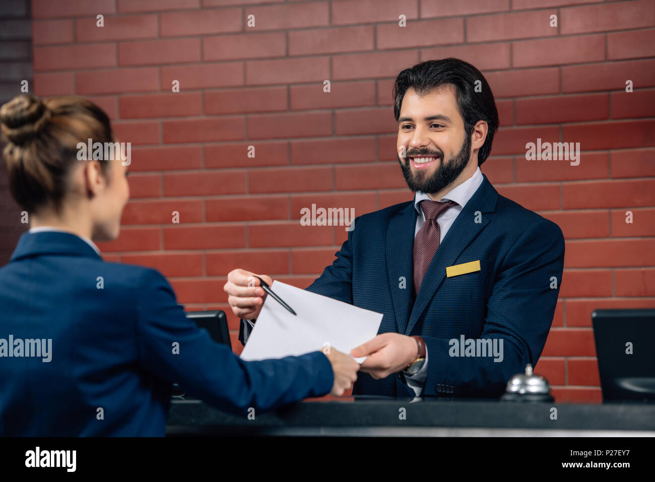 hotel receptionist showing contract customer at counter Stock Photo - Alamy